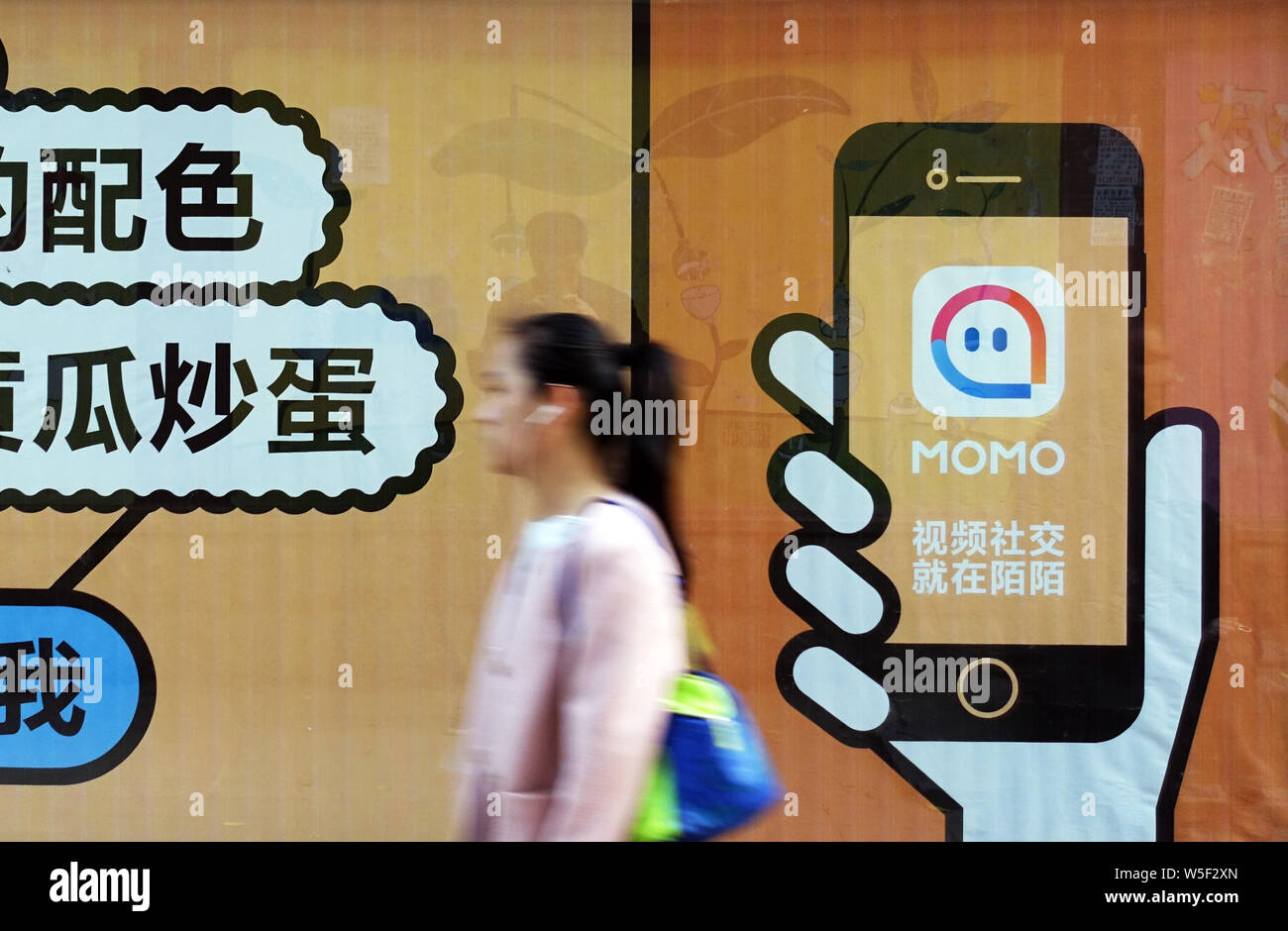 --FILE--A pedestrian walks past an advertisement of mobile social ...