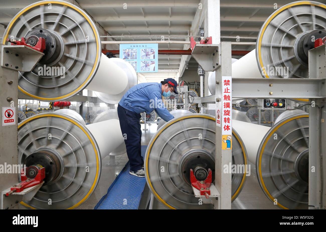 --FILE--A Chinese worker handles production of yarn at a textile ...