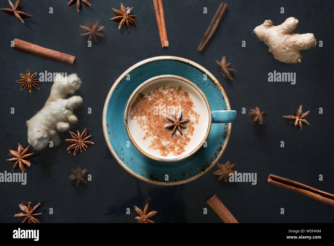 Masala Indian tea or coffee in cup with spices on black concrete table ...