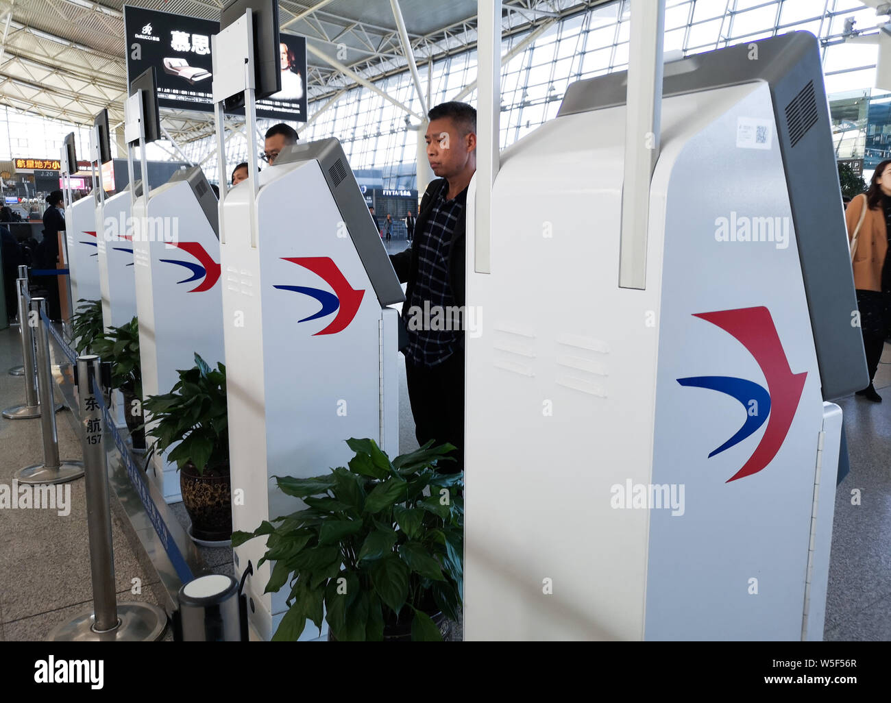 --FILE--Passengers use self-service electronic ticket check-in machines ...
