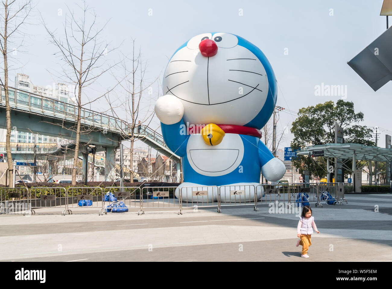 A kid poses for photos with a 10-meter-tall inflated doll featuring ...