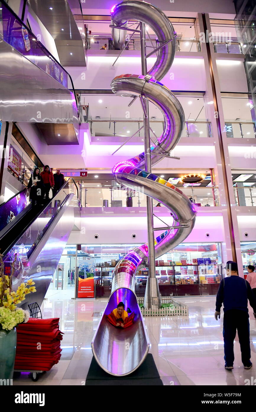 A customer tries out the 20-meter tall super slide at a shopping mall ...