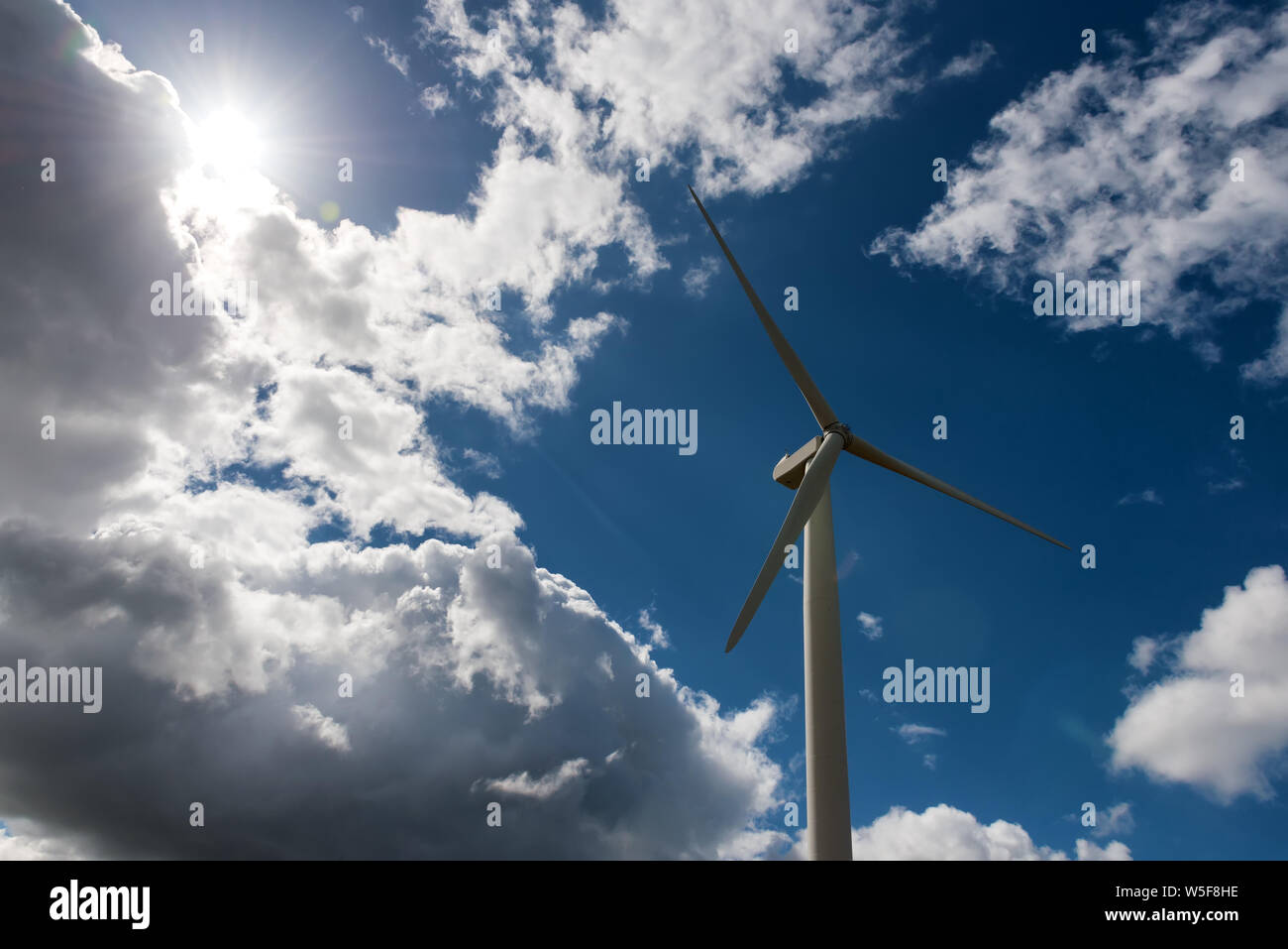Sun shinig on windmill, cloudy blue sky backround Stock Photo - Alamy