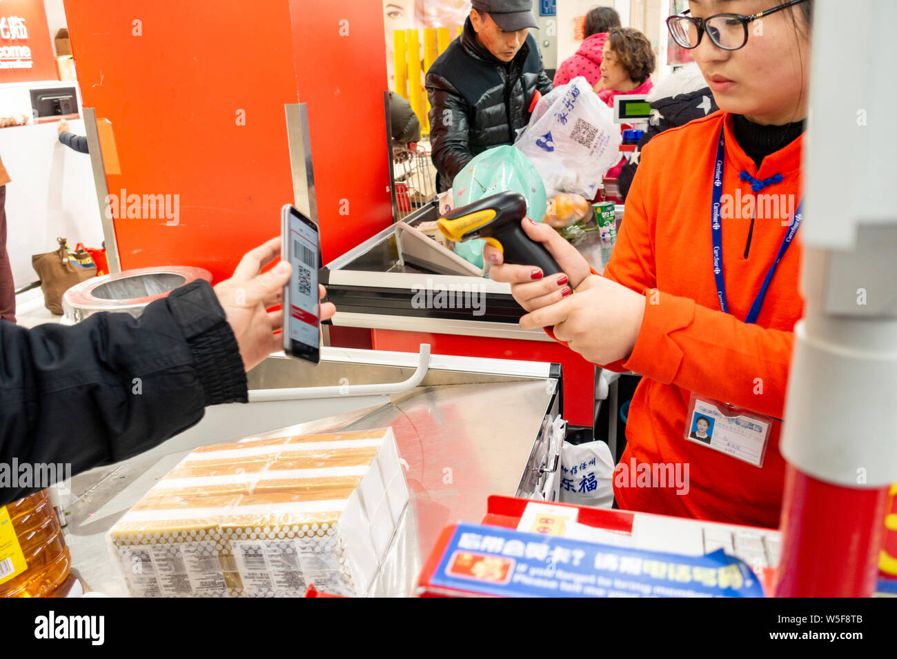 --FILE--A Chinese cashier scans the QR code through mobile payment ...