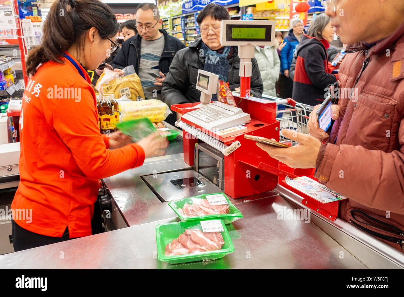 --FILE--A Chinese cashier scans the QR code through mobile payment ...