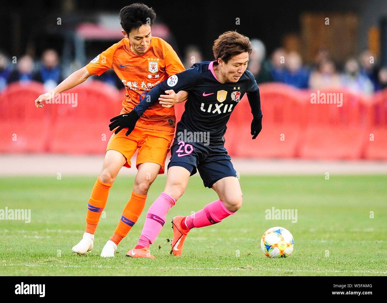 Wu Xinghan of China's Shandong Luneng, left, challenges Kento Misao of Japan's Kashima Antlers ...