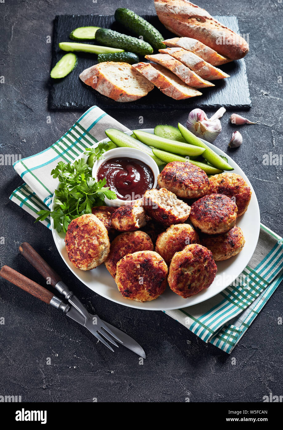 Polish Meat rissoles served with cucumber slices and barbeque sauce on ...