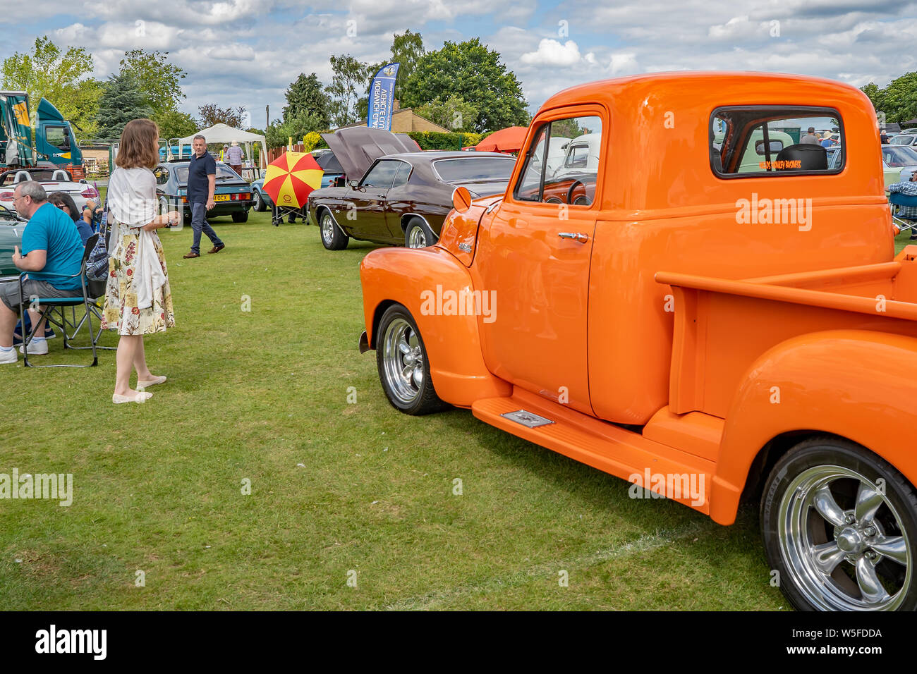 A young lady in a flowery dress admiring the classic, vintage and retro ...