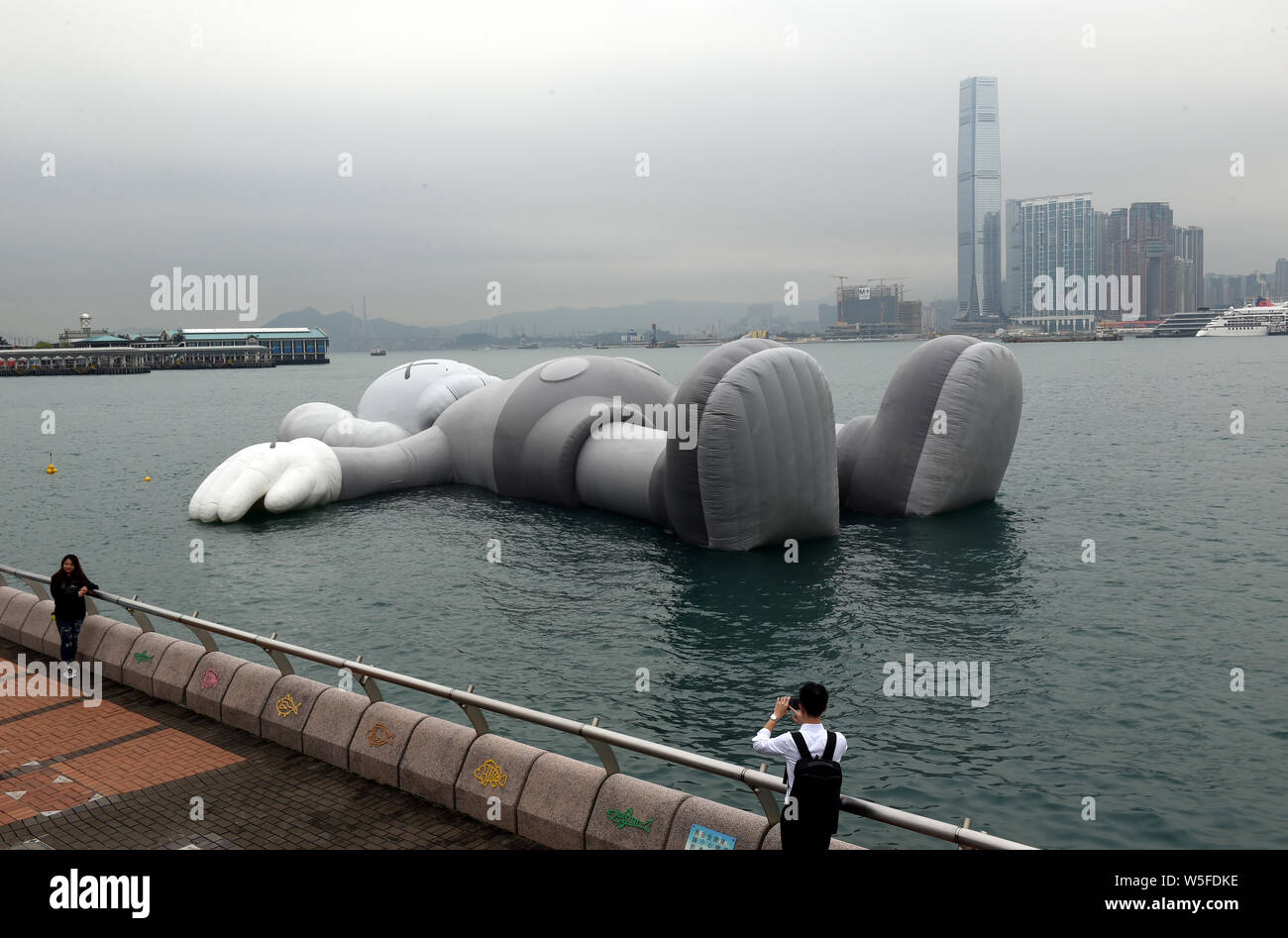 Visitors view the 37-metre-long floating sculpture by US artist Kaws at ...