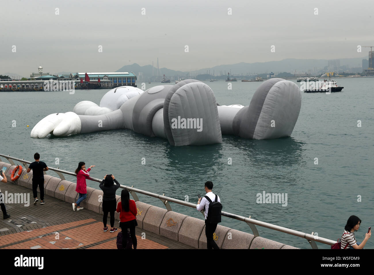 Visitors view the 37-metre-long floating sculpture by US artist Kaws at ...