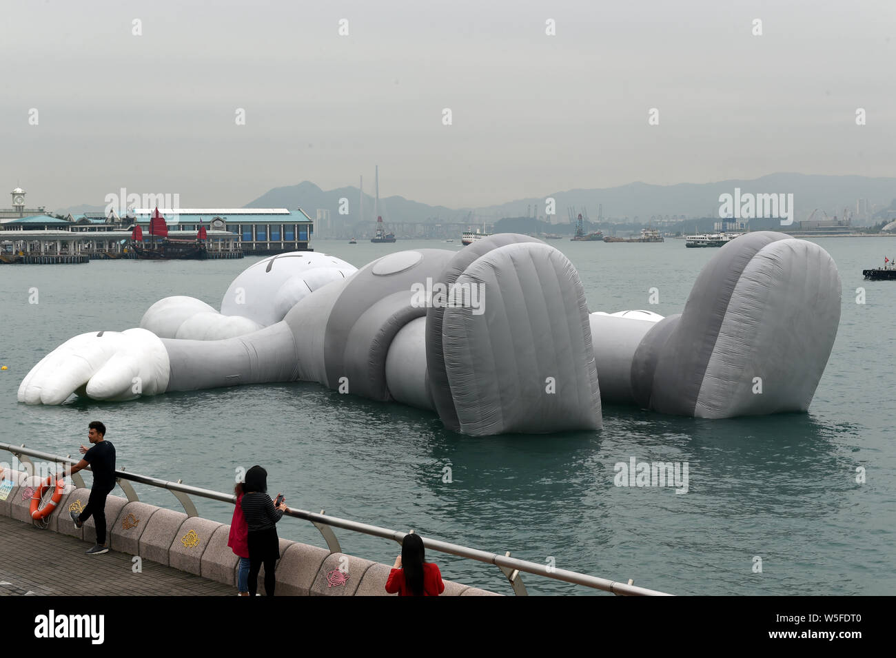 Visitors view the 37-metre-long floating sculpture by US artist Kaws at ...