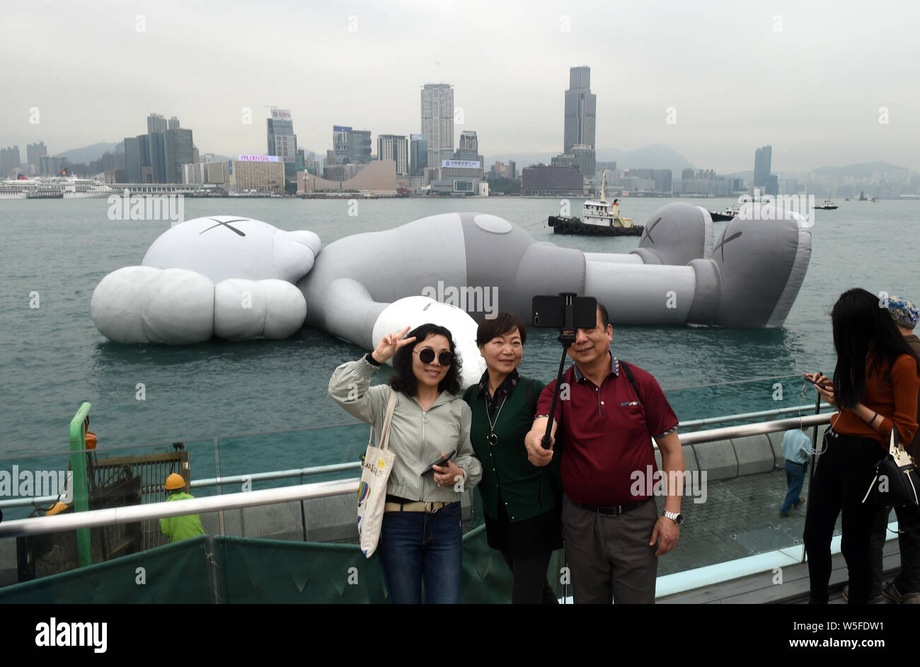 Visitors view the 37-metre-long floating sculpture by US artist Kaws at ...