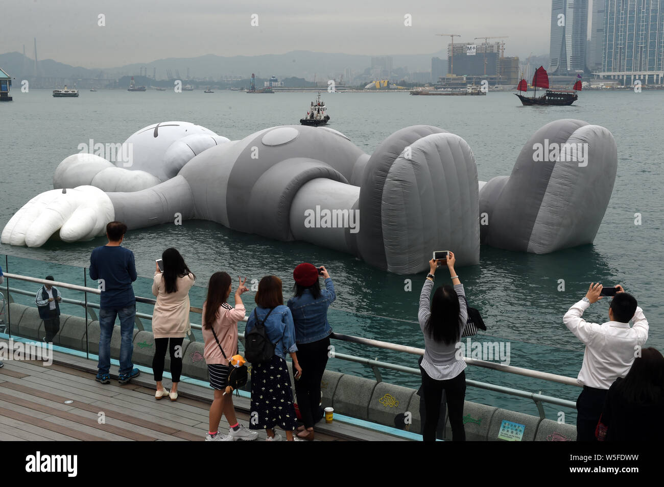 Visitors view the 37-metre-long floating sculpture by US artist Kaws at ...