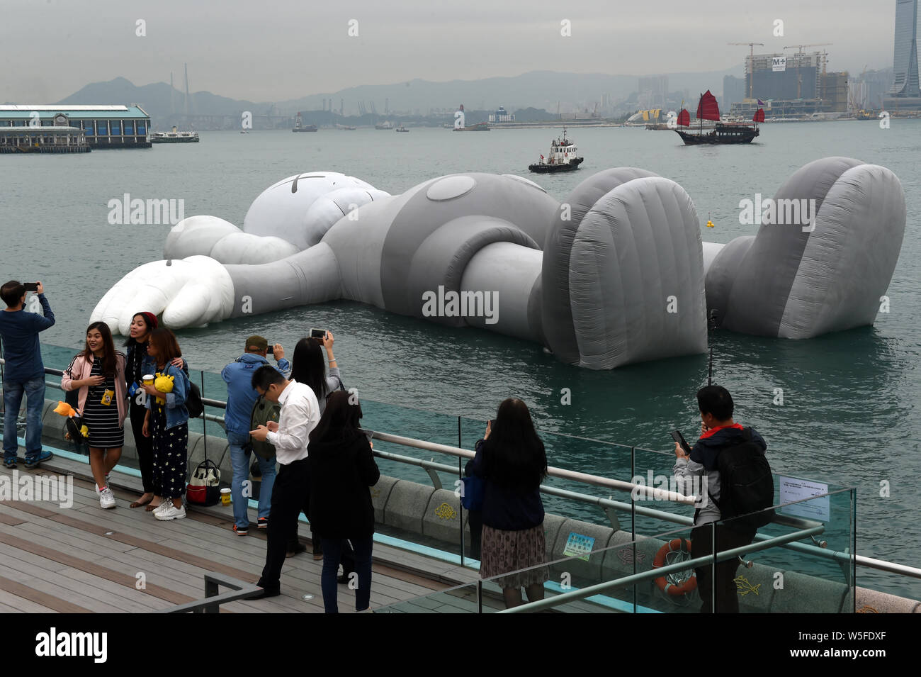 Visitors view the 37-metre-long floating sculpture by US artist Kaws at ...
