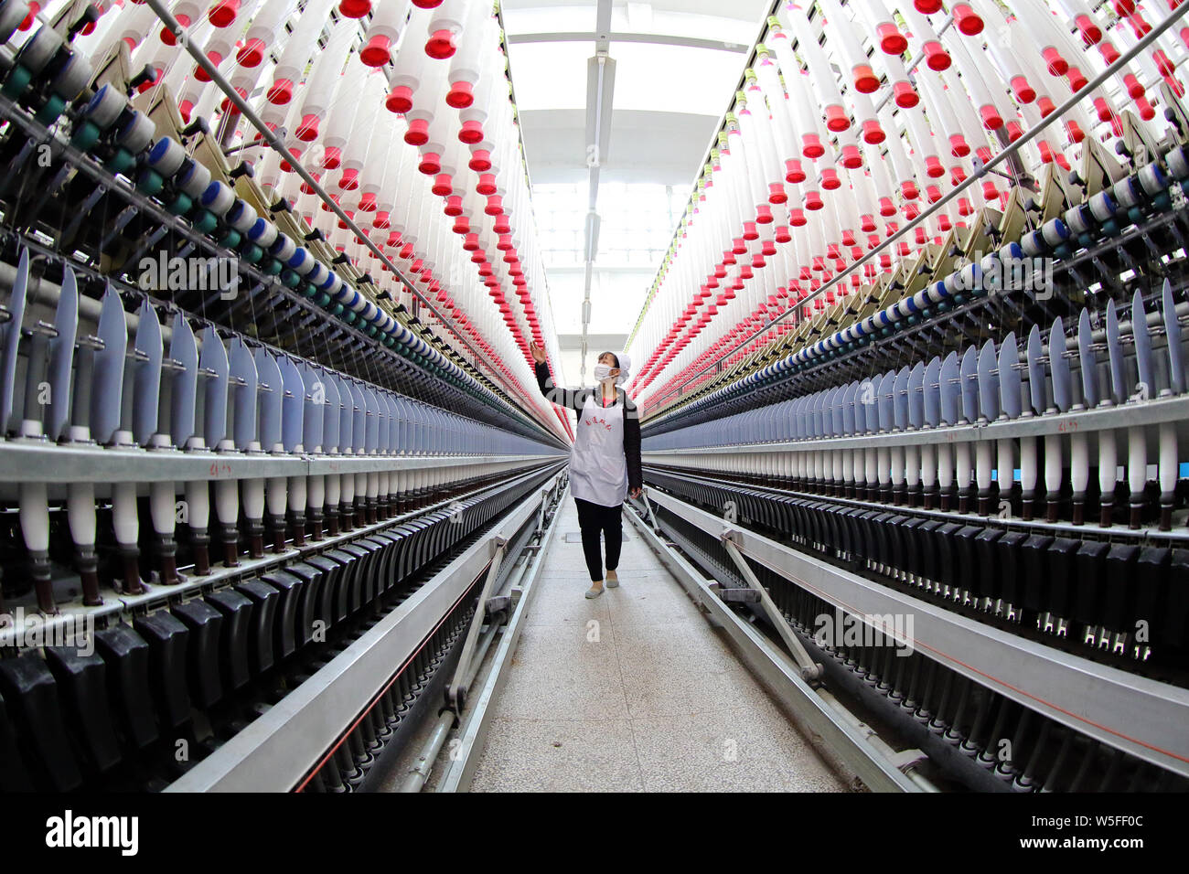 --FILE--A female Chinese worker handles production of yarn at a textile ...