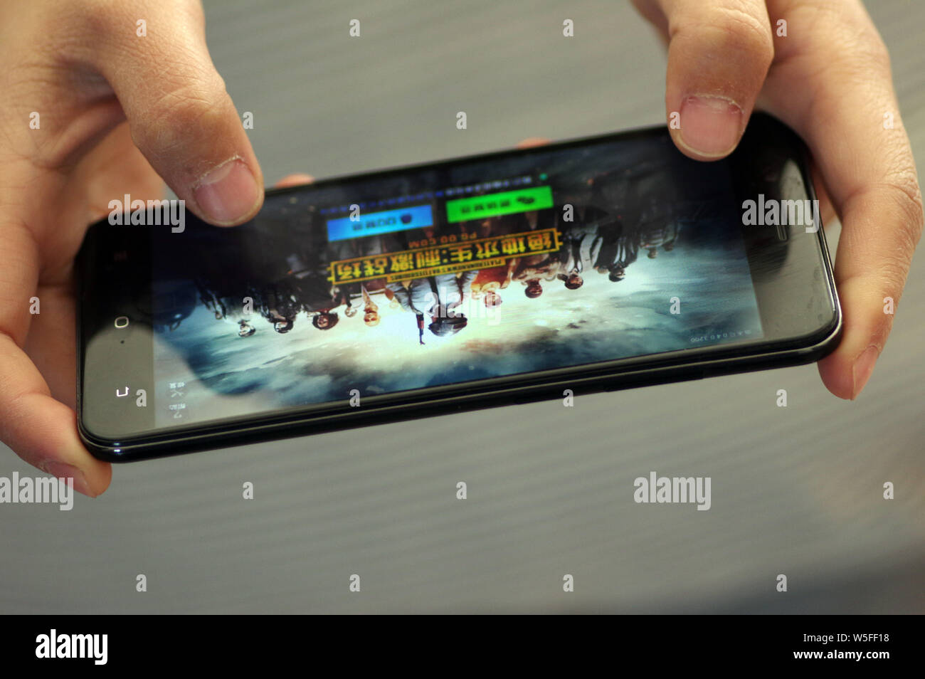 --FILE--A Chinese mobile game player plays Tencent's multiplayer online ...