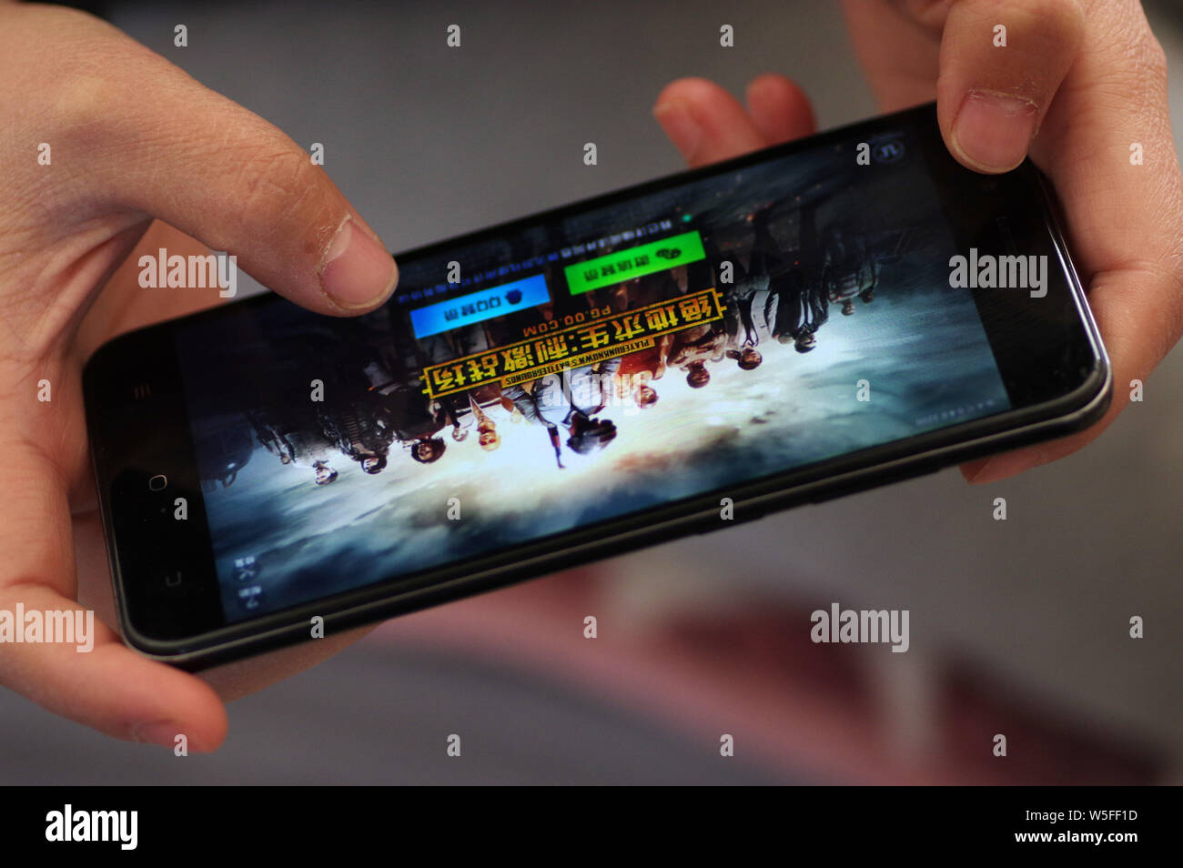 --FILE--A Chinese mobile game player plays Tencent's multiplayer online ...