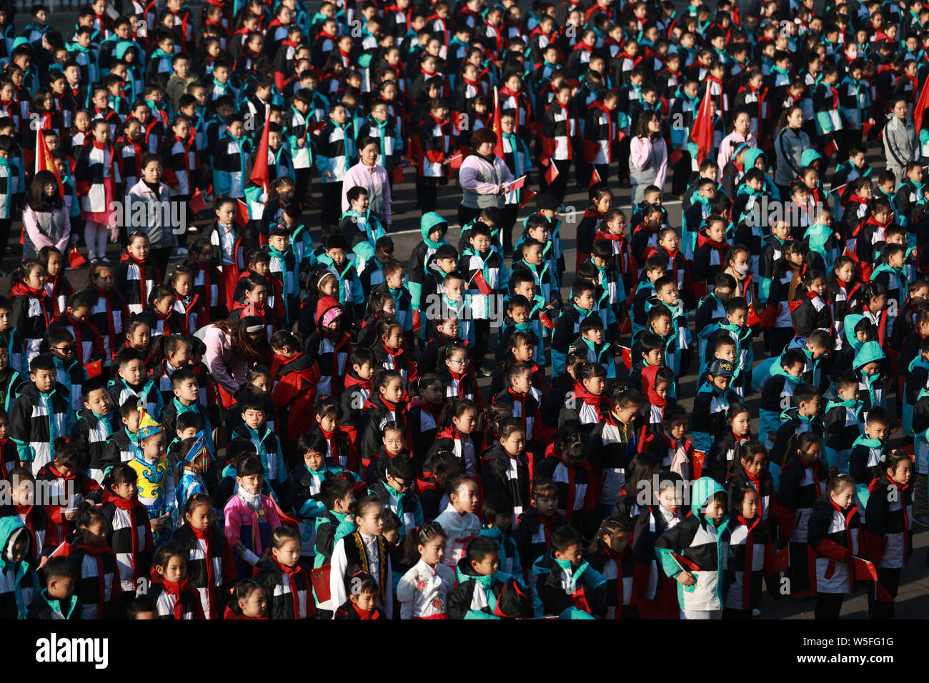 Young Chinese students wave Chinese national flags during the flag ...