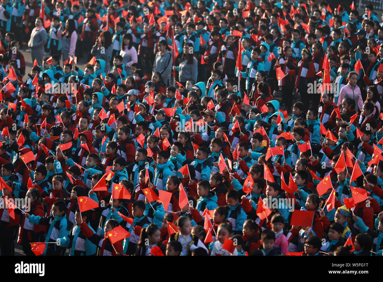 Young Chinese students wave Chinese national flags during the flag ...