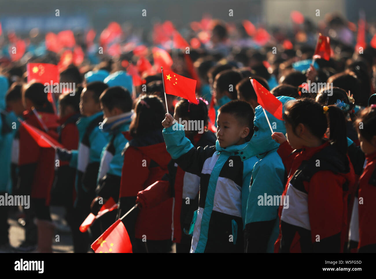 Young Chinese students wave Chinese national flags during the flag ...