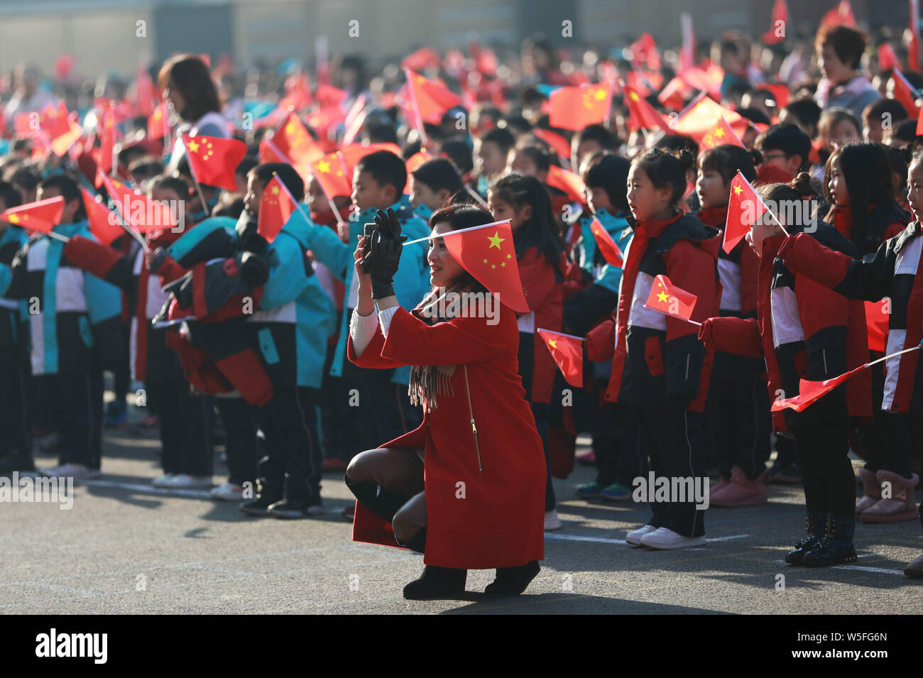 Young Chinese students wave Chinese national flags during the flag ...
