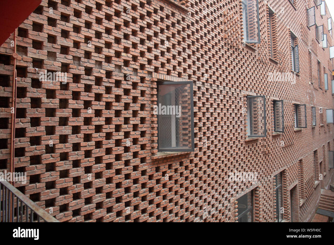 The holes are strewn on the surface of a building at the campus of a ...