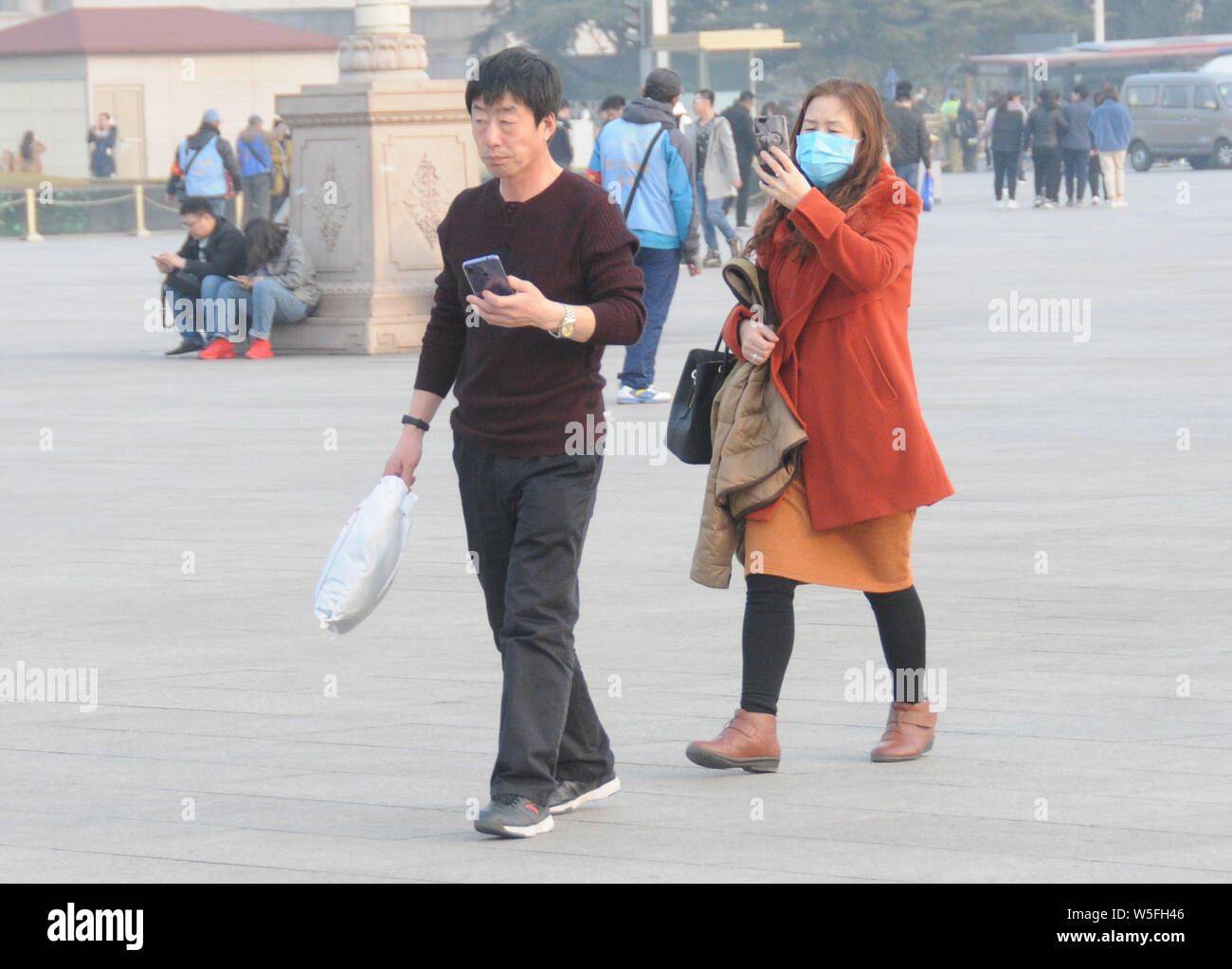 Tourists wearing face masks against air pollution visit the Tian'anmen ...