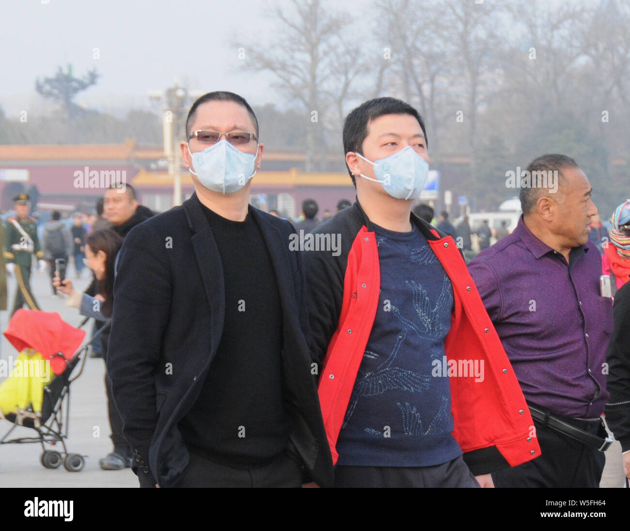 Tourists wearing face masks against air pollution visit the Tian'anmen ...
