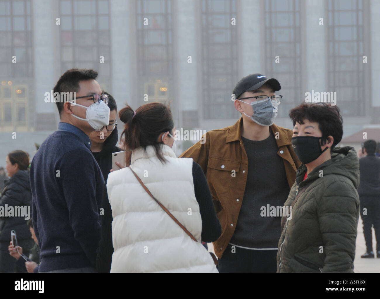 Tourists wearing face masks against air pollution visit the Tian'anmen ...