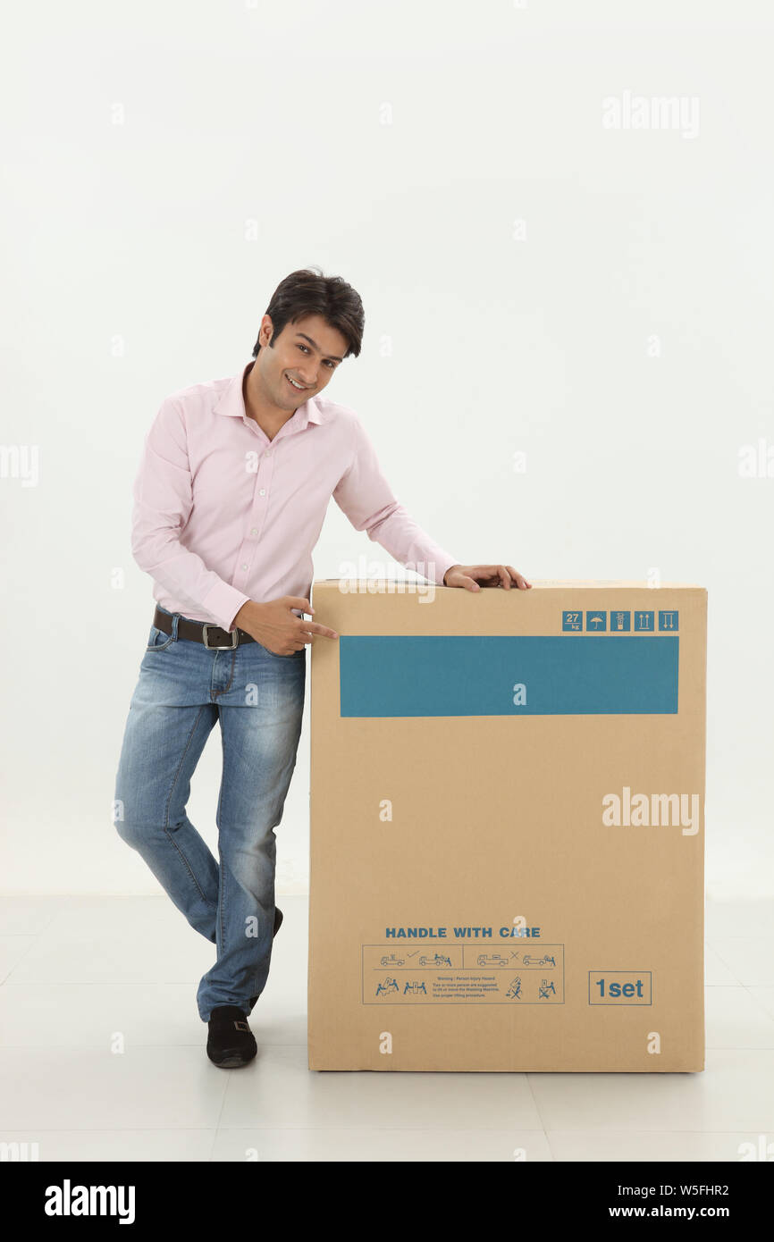 Salesman showing a cardboard box and smiling Stock Photo - Alamy