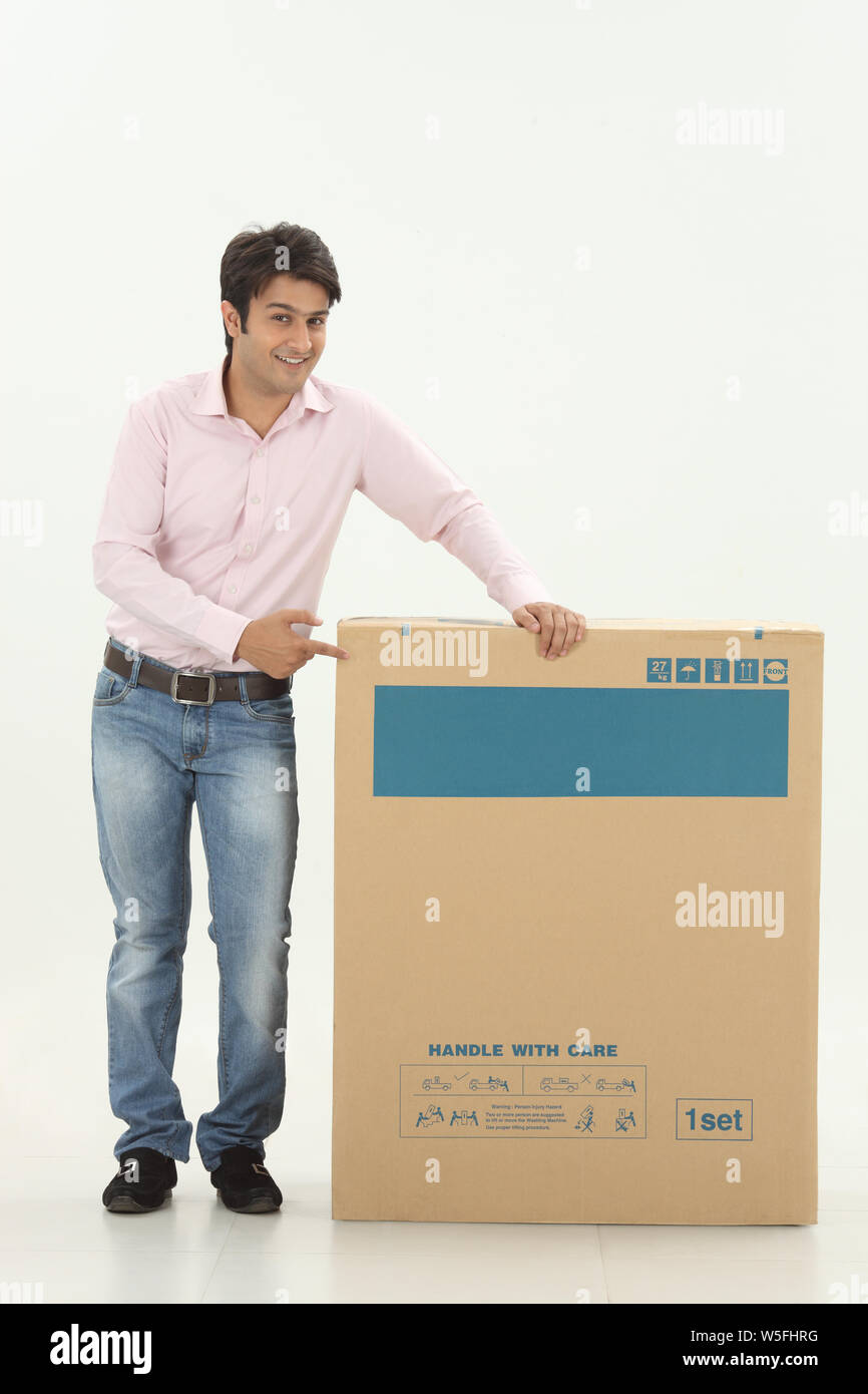 Salesman showing a cardboard box and smiling Stock Photo - Alamy
