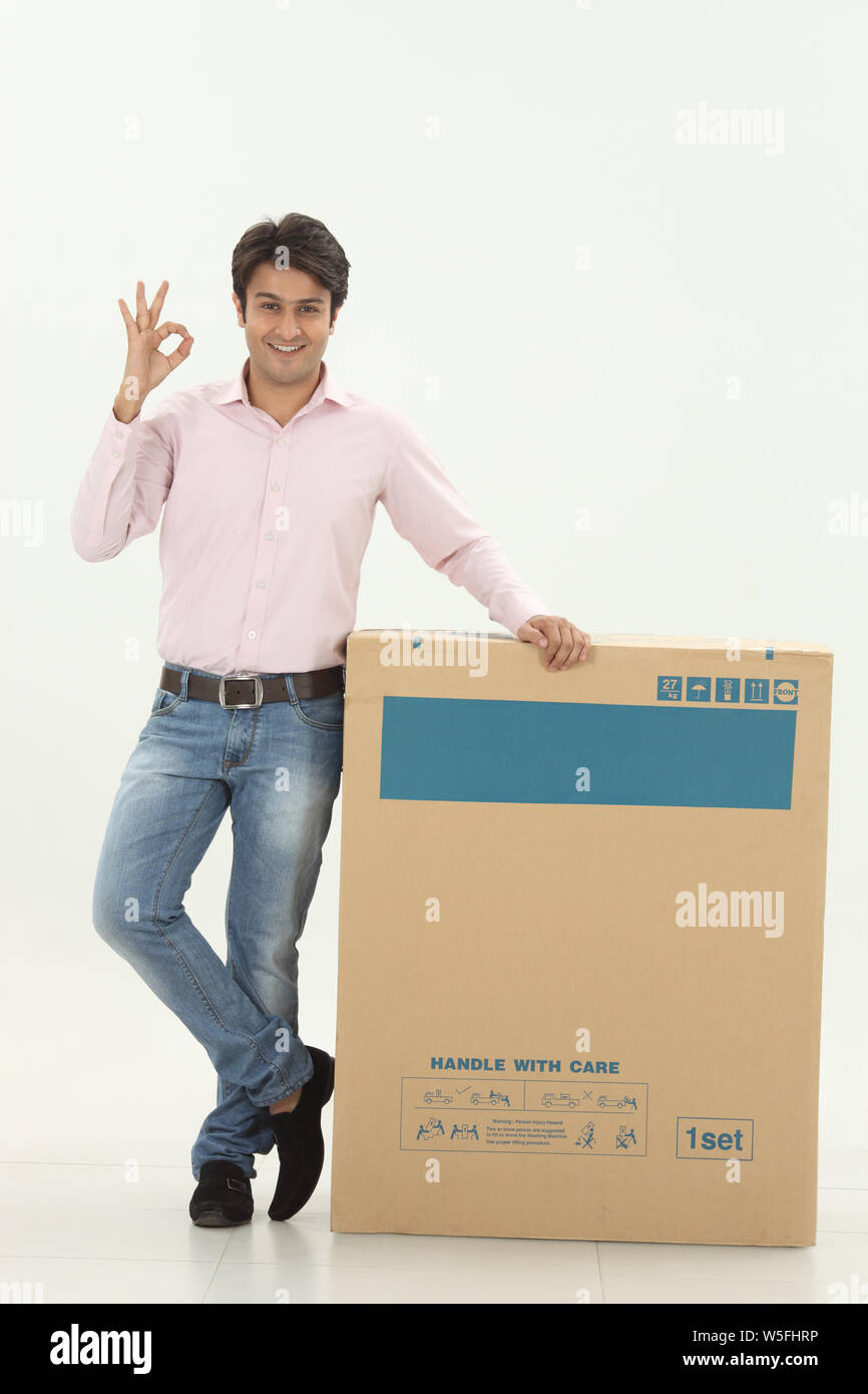 Salesman standing with a cardboard box and showing ok sign Stock Photo ...