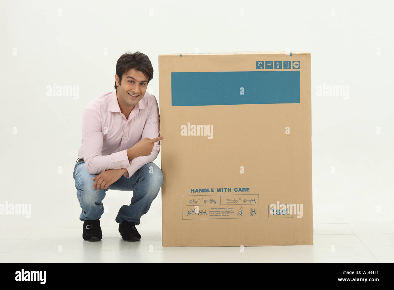 Salesman showing a cardboard box and smiling Stock Photo - Alamy