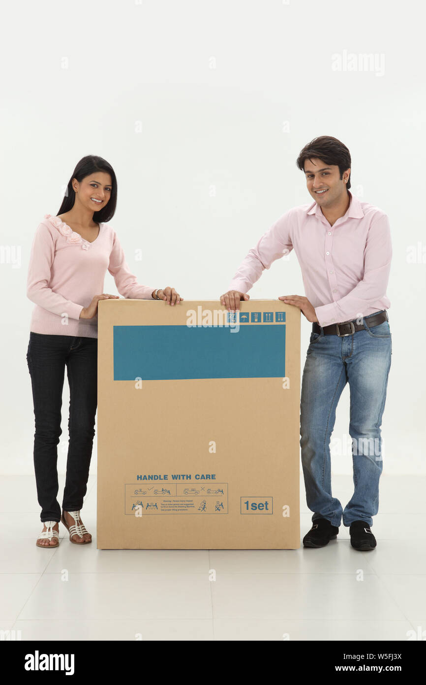 Couple with a cardboard box smiling Stock Photo - Alamy