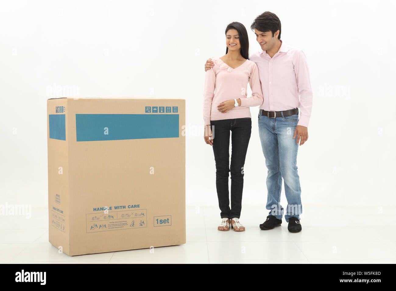 Couple looking at a cardboard box and smiling Stock Photo - Alamy