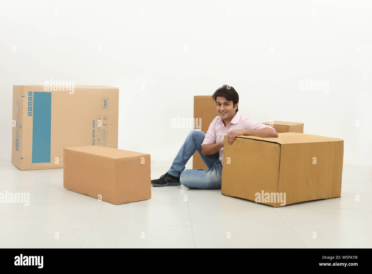 Man sitting with cardboard boxes Stock Photo - Alamy
