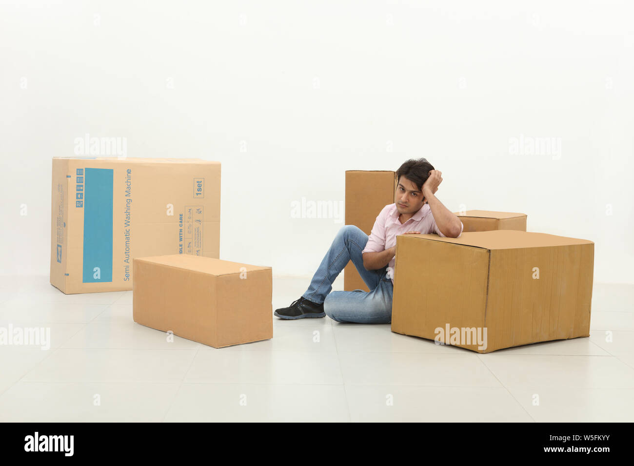 Man sitting with cardboard boxes Stock Photo - Alamy