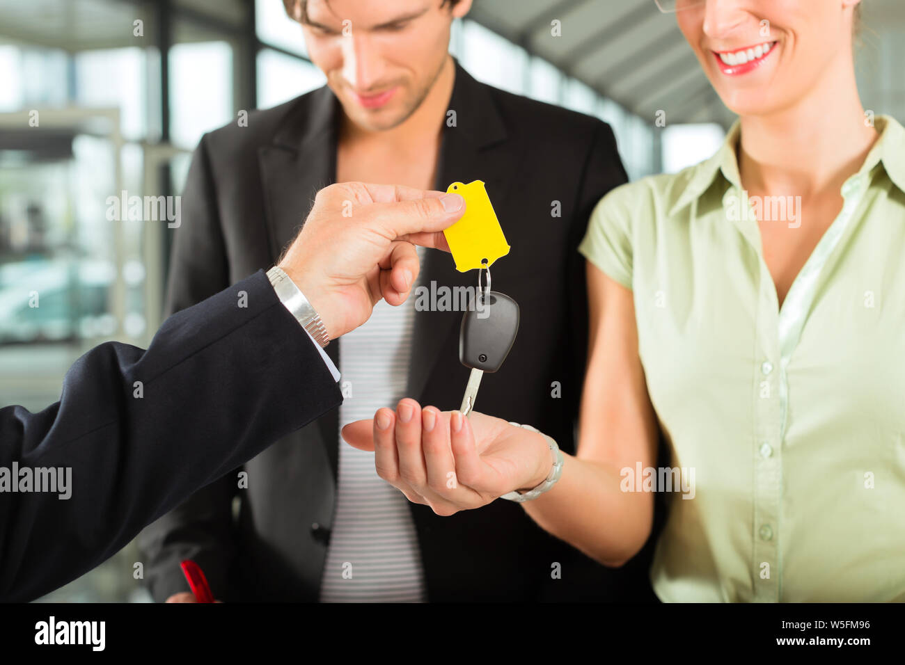 Agent giving keys to couple Stock Photo - Alamy