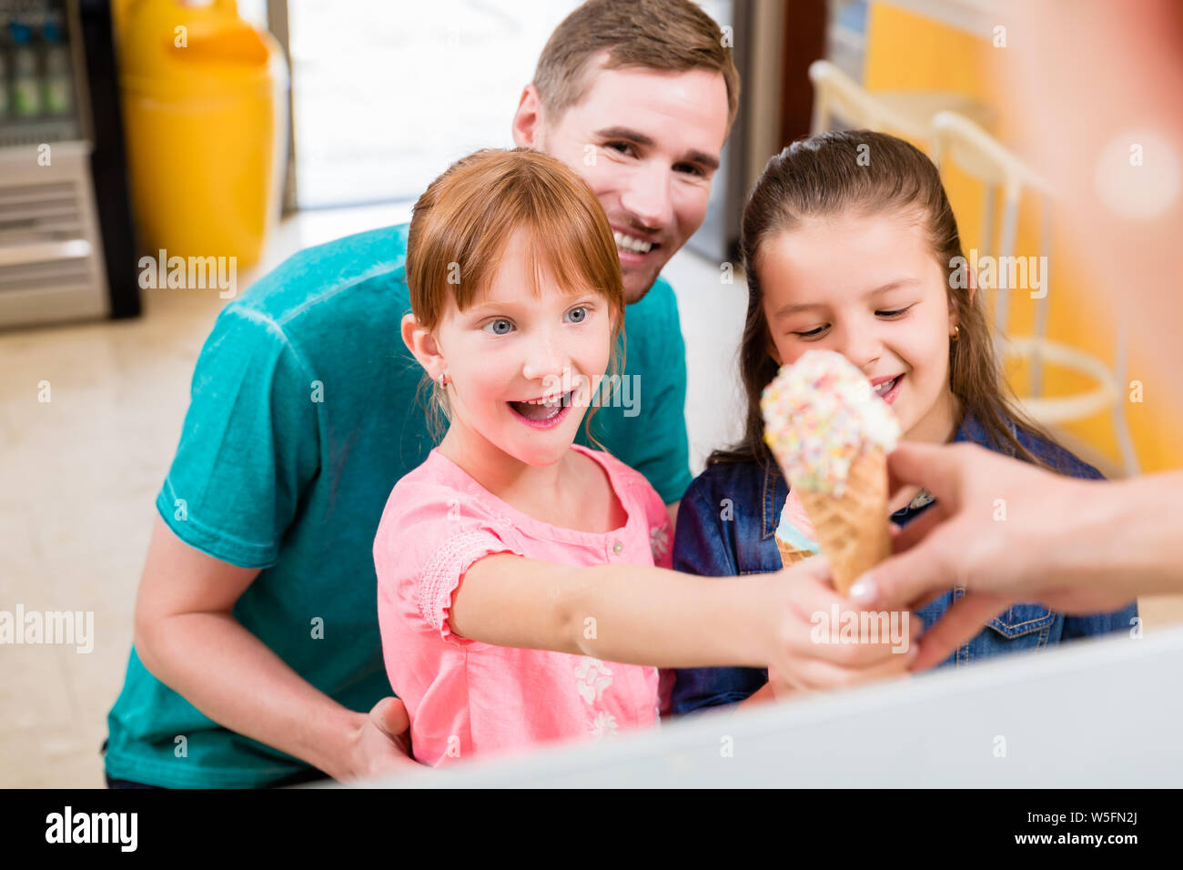 Little girl getting her ice cream cone at the counter of a cafe Stock ...