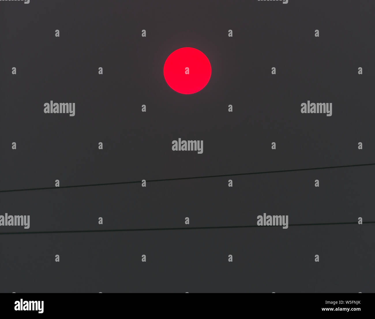 Close-Up of Red Sun Circle In Hazy City Air with Two Hanging Wires ...