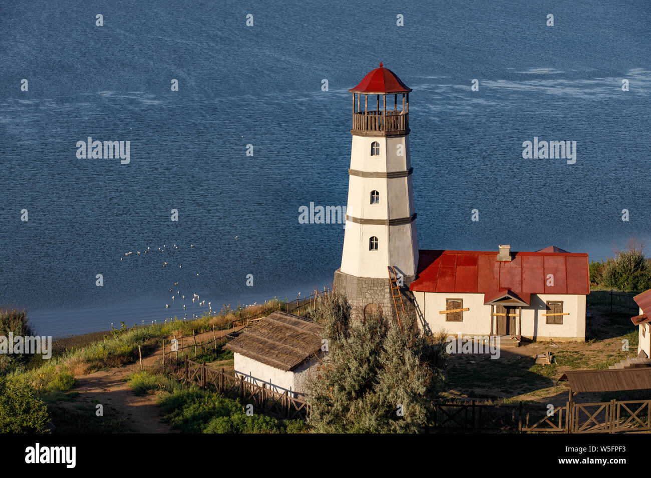 Old lighthouse with a red roof on the sea shore in the morning Stock ...