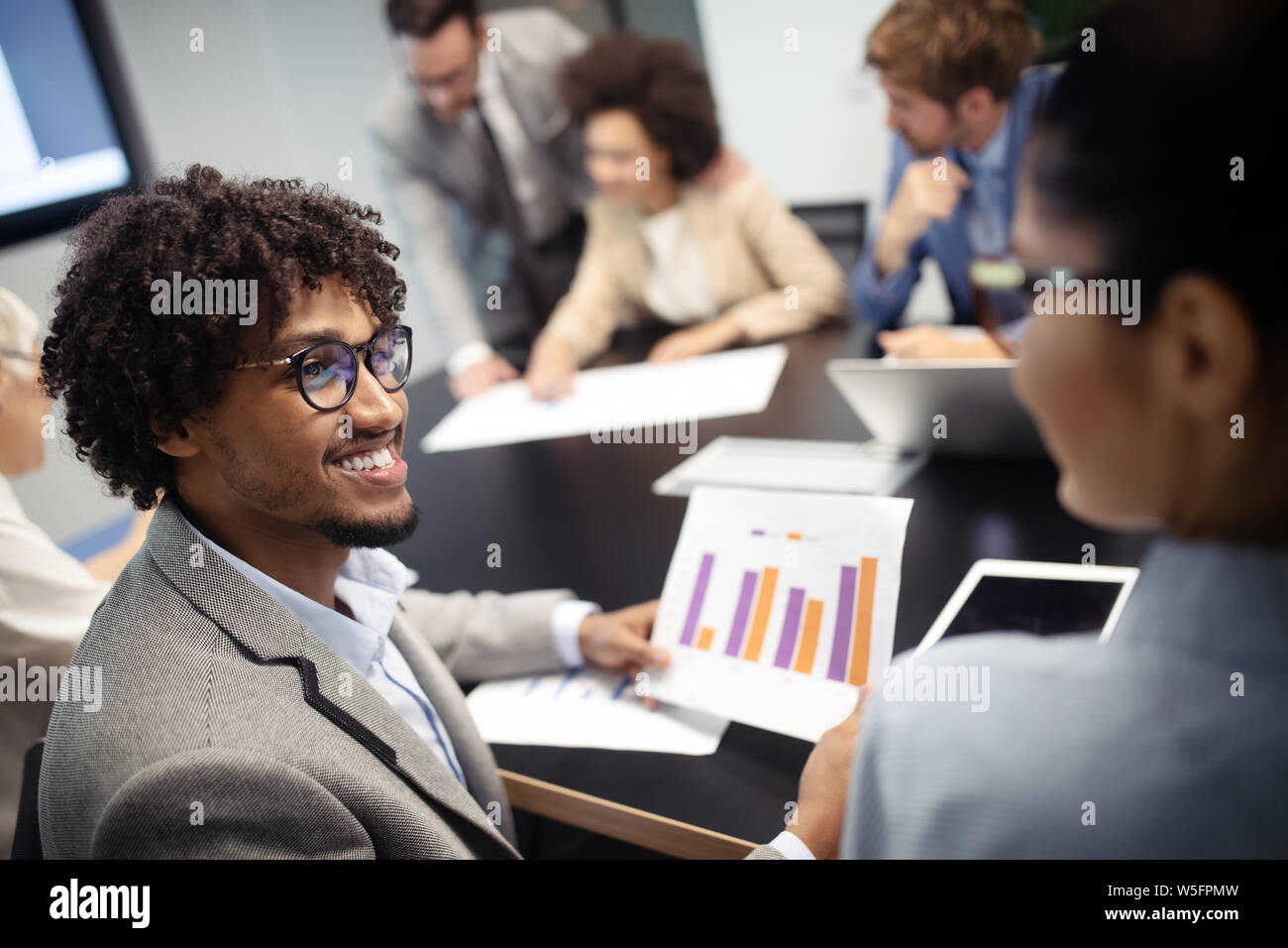Happy business colleagues in modern office working together Stock Photo ...