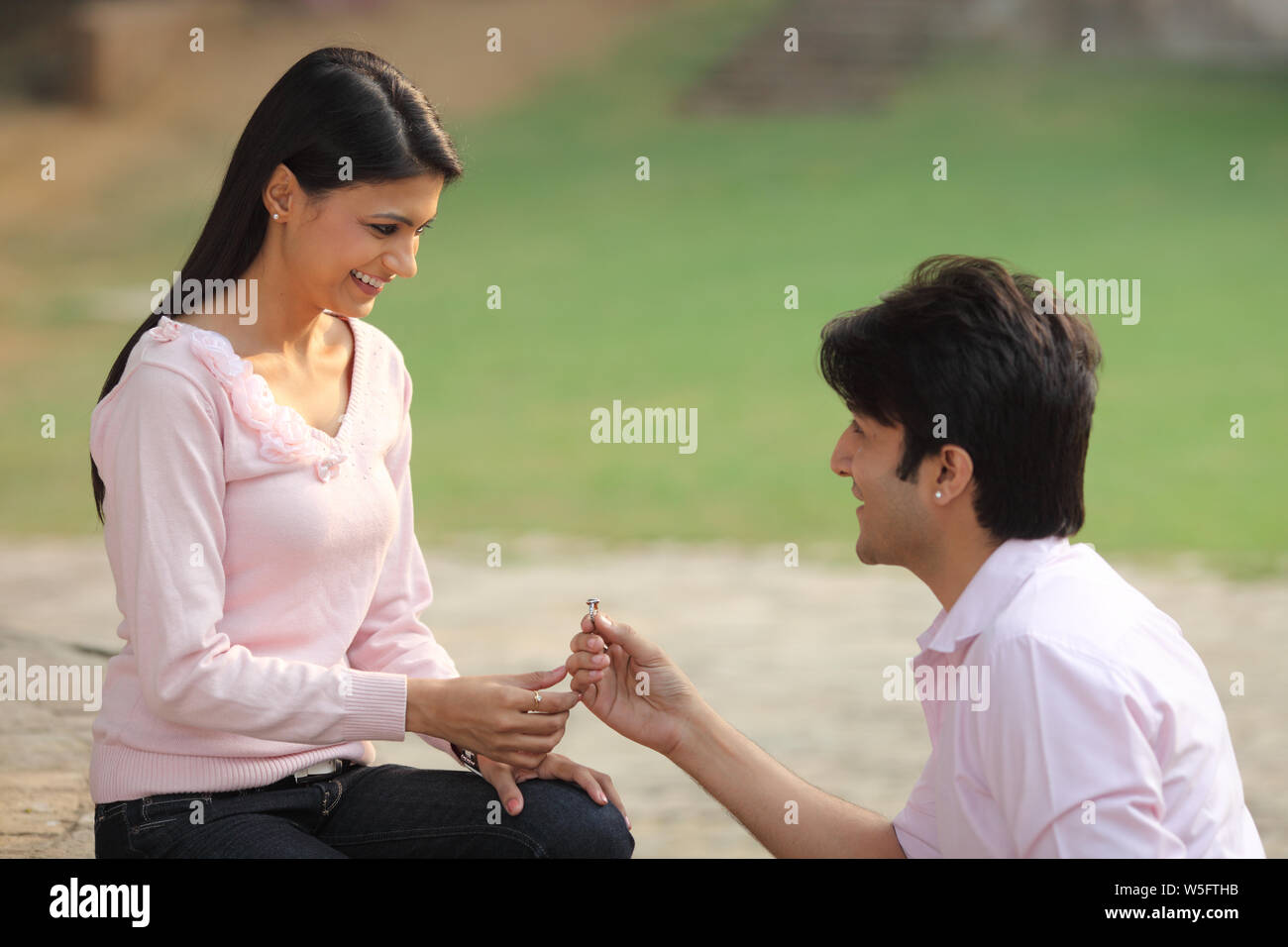 Man giving an engagement ring to a woman and smiling Stock Photo - Alamy