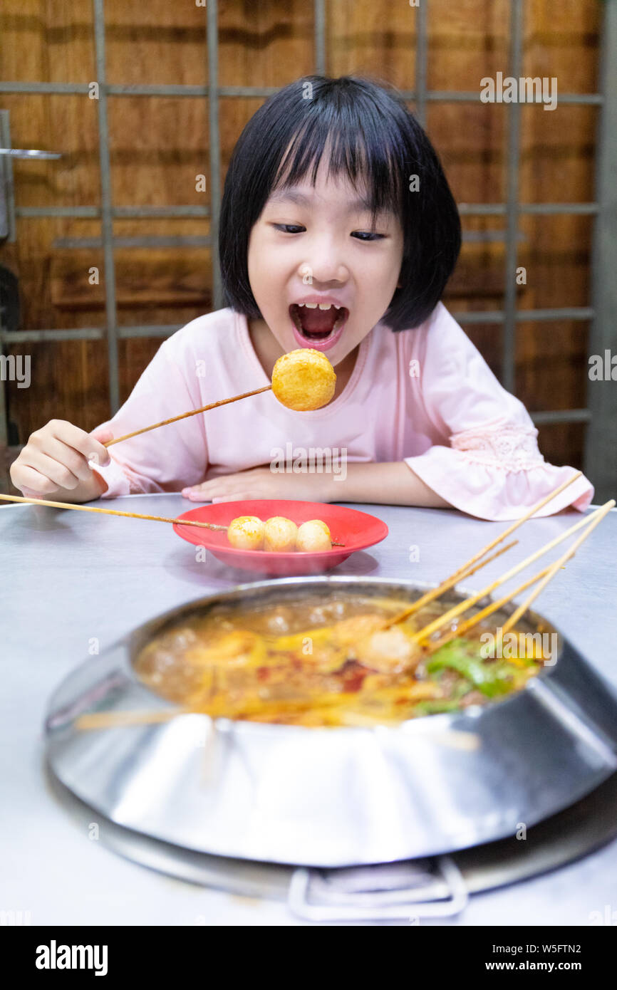 Asian Little Chinese Girl eating hot pot in a restaurant of Melaka ...