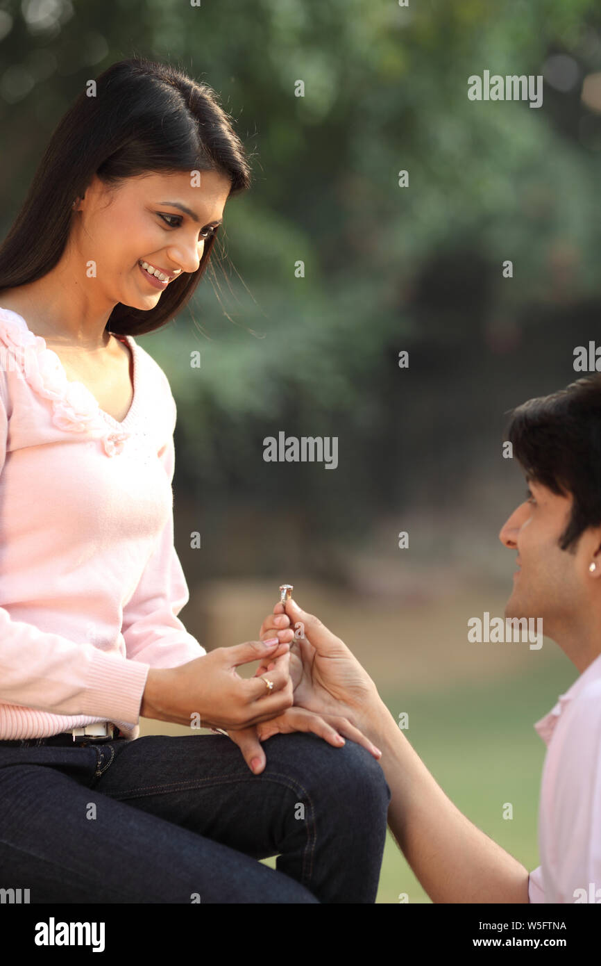 Man giving an engagement ring to a woman and smiling Stock Photo - Alamy