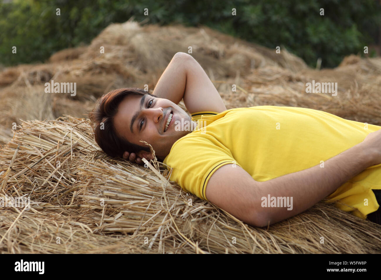 Man relaxing on hay and smiling Stock Photo - Alamy