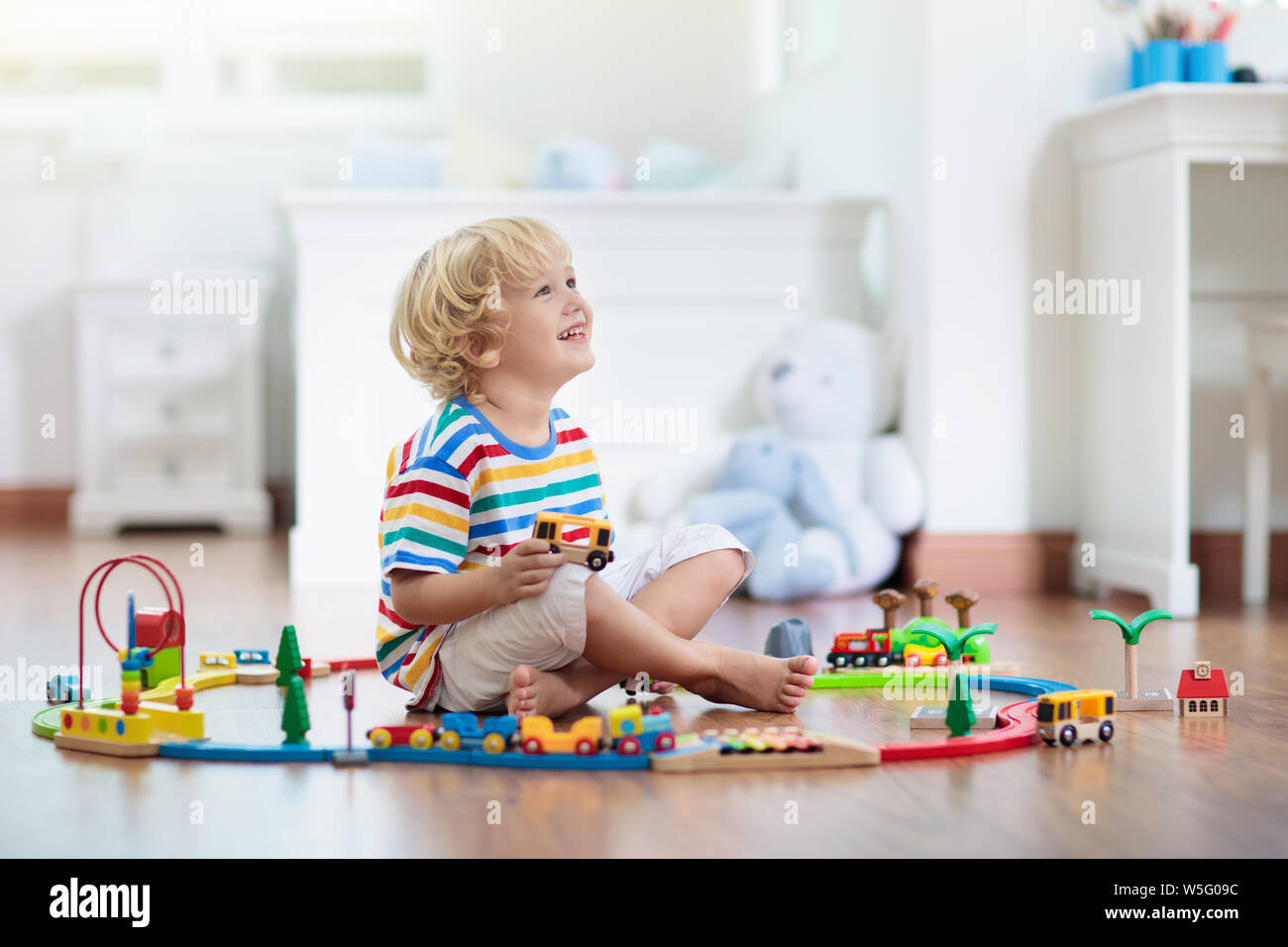 Kids play with wooden railway. Child with toy train. Educational toys ...