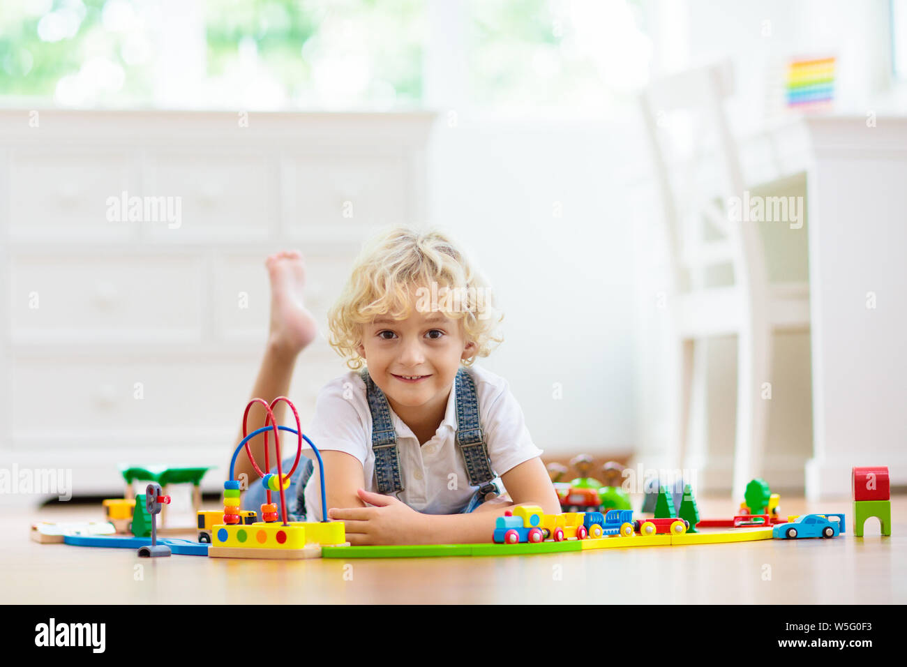 Kids play with wooden railway. Child with toy train. Educational toys ...