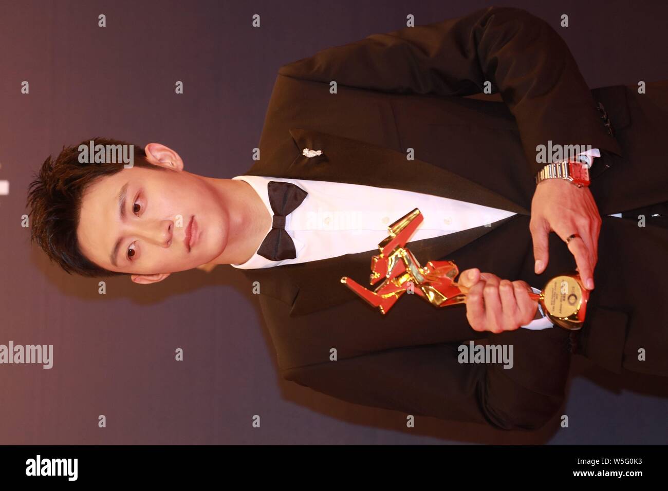 Chinese actor Johnny Huang Jingyu poses with his trophy after winning ...