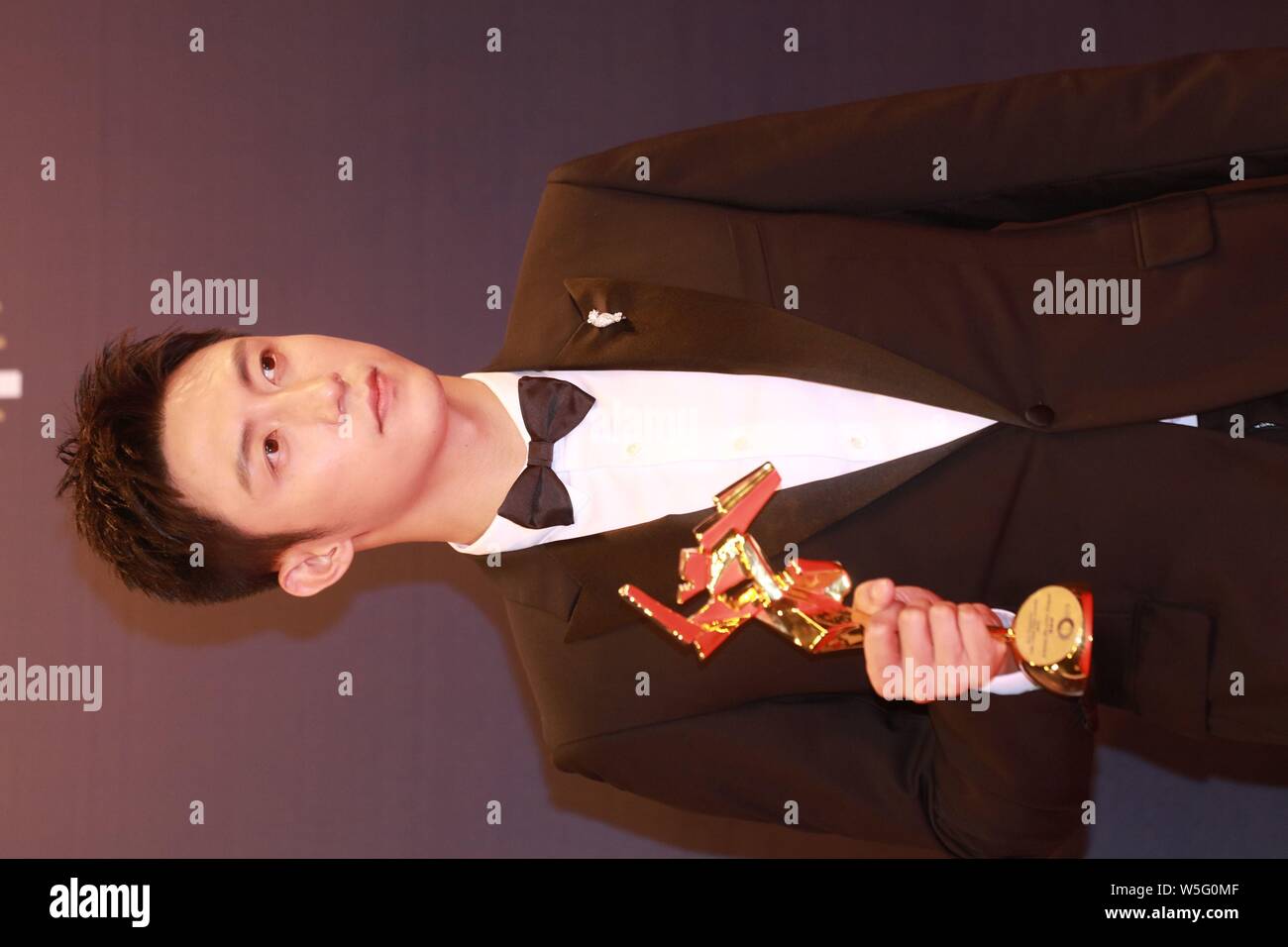Chinese actor Johnny Huang Jingyu poses with his trophy after winning ...